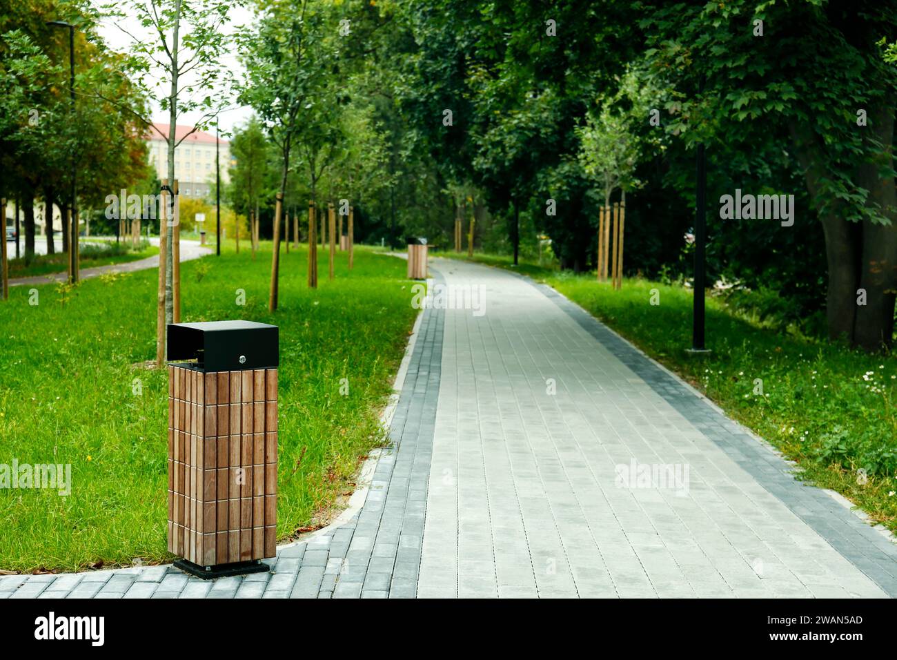 View of park with alley and garbage bin Stock Photo - Alamy