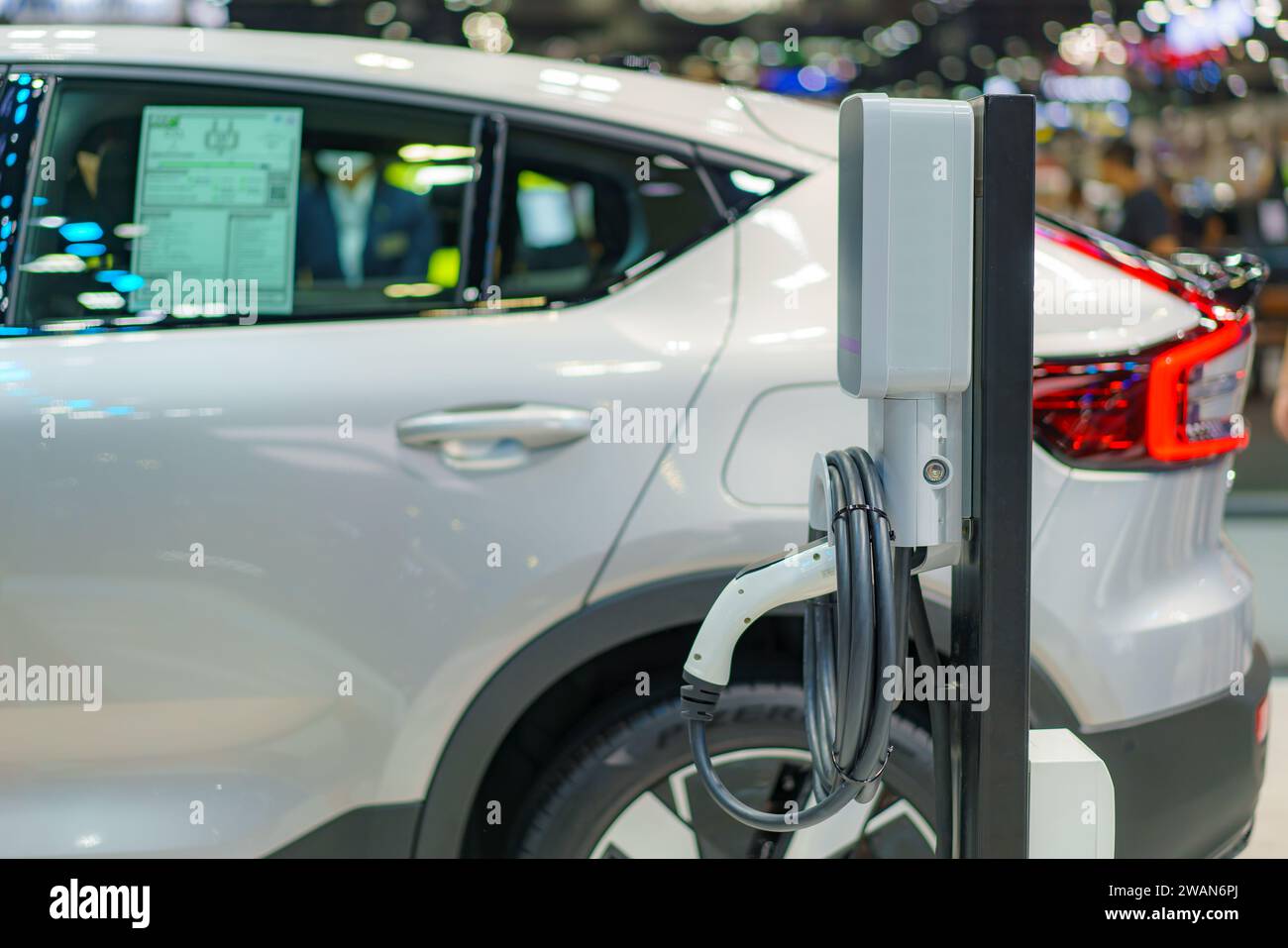 EV car rests at a charging station, power cable connected, embodying ...