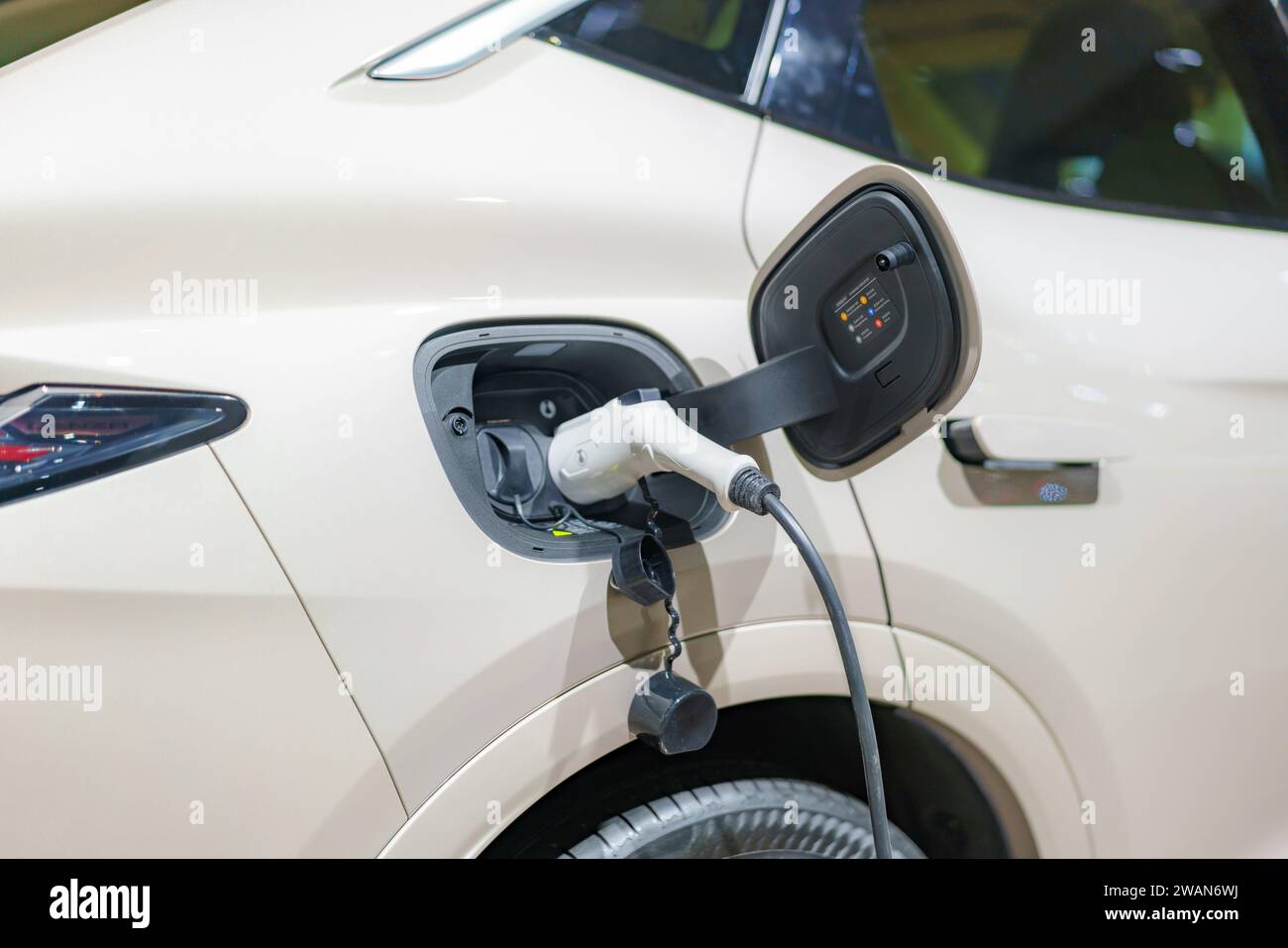 EV car rests at a charging station, power cable connected, embodying ...