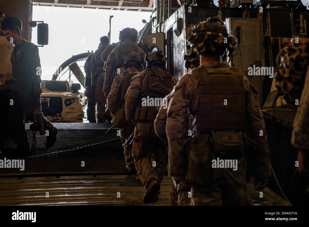 Marines assigned to the 15th Marine Expeditionary Unit transport gear ...