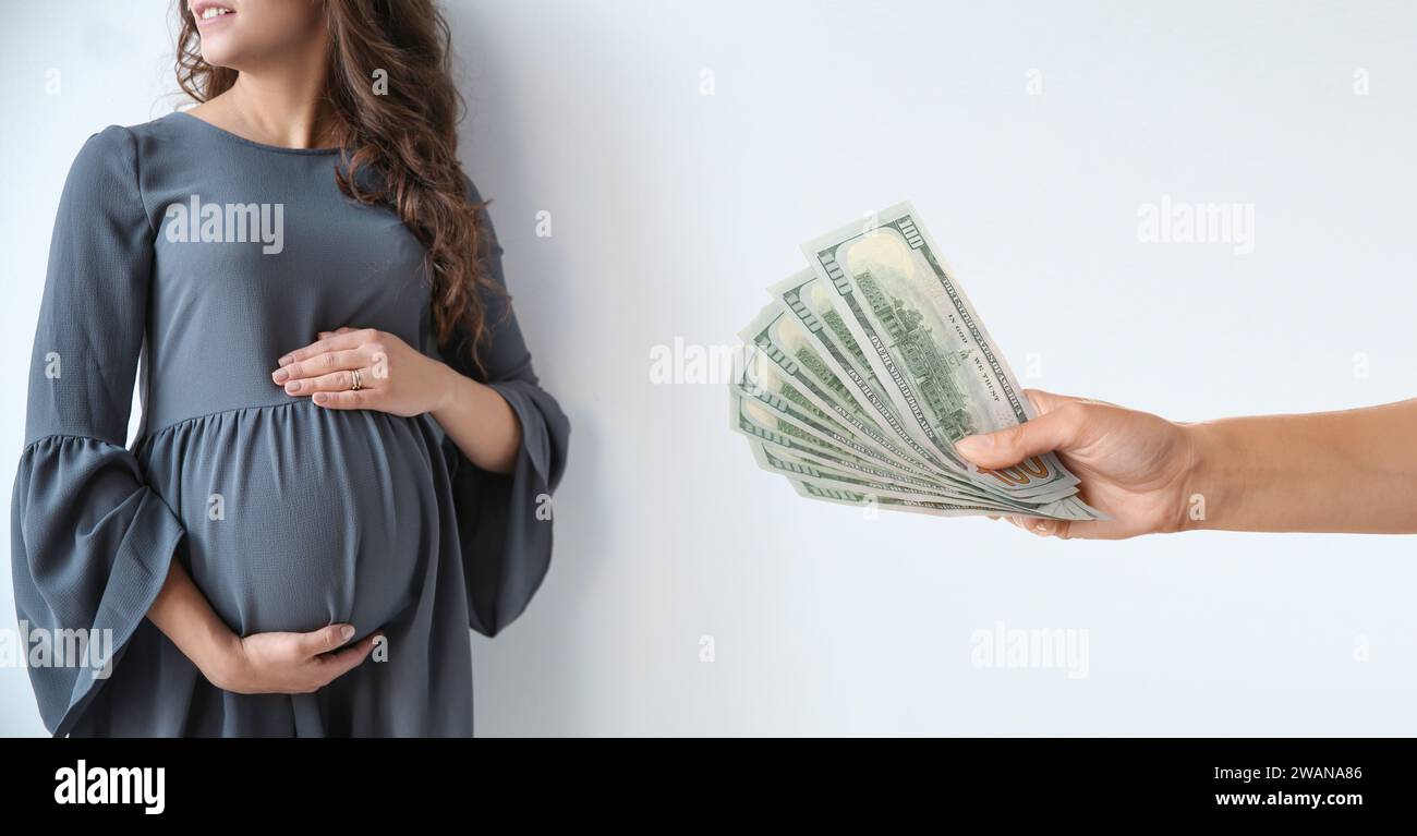 Surrogacy. Intended mother with money and pregnant woman on light ...