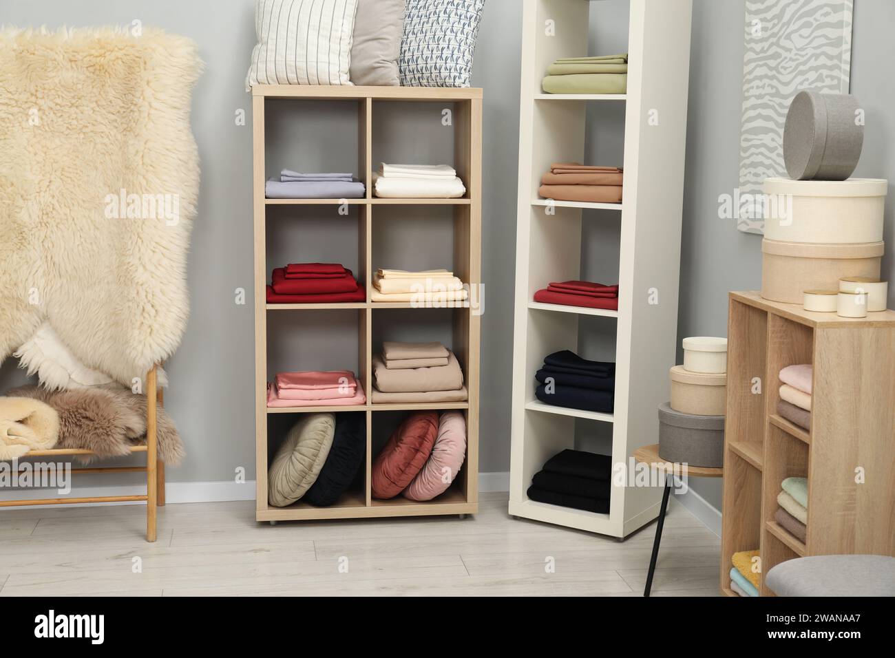 Different colorful bed linens and decorative boxes on display in home ...