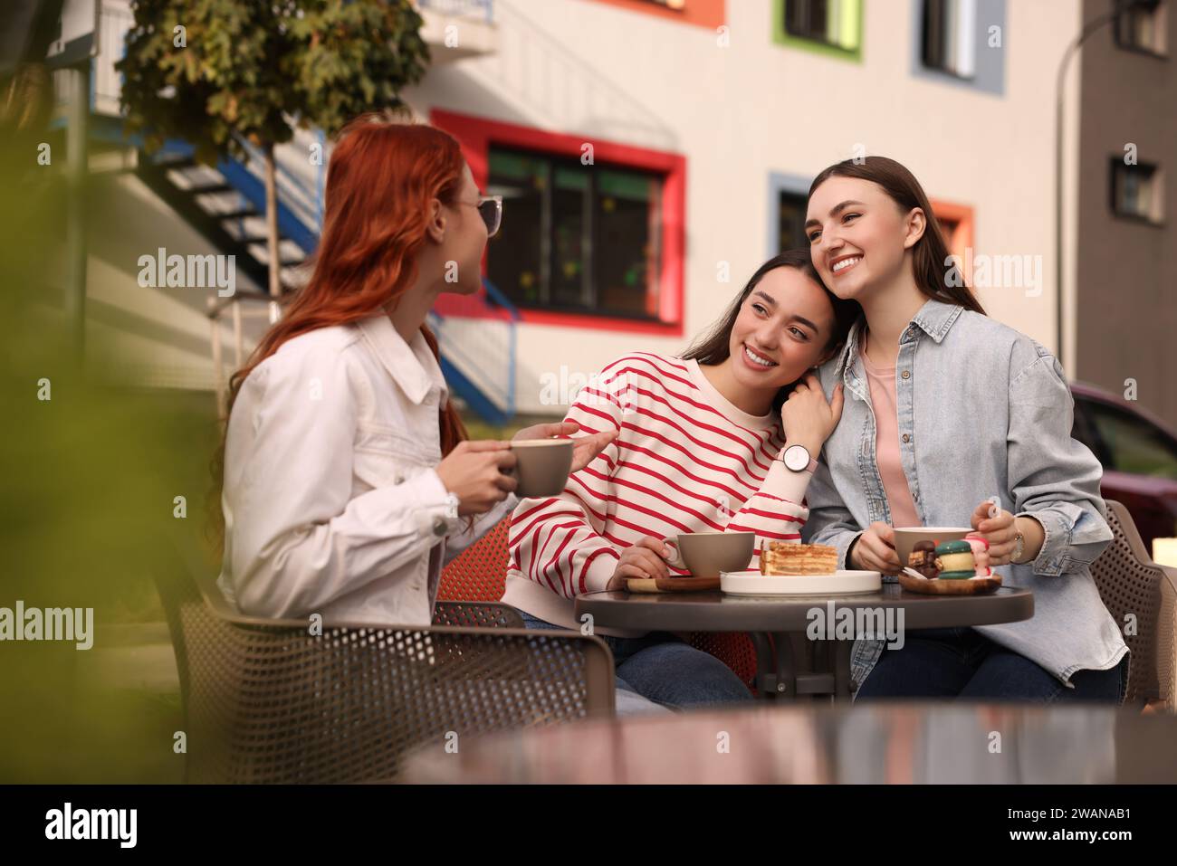 Happy friends talking and drinking coffee in outdoor cafe Stock Photo ...