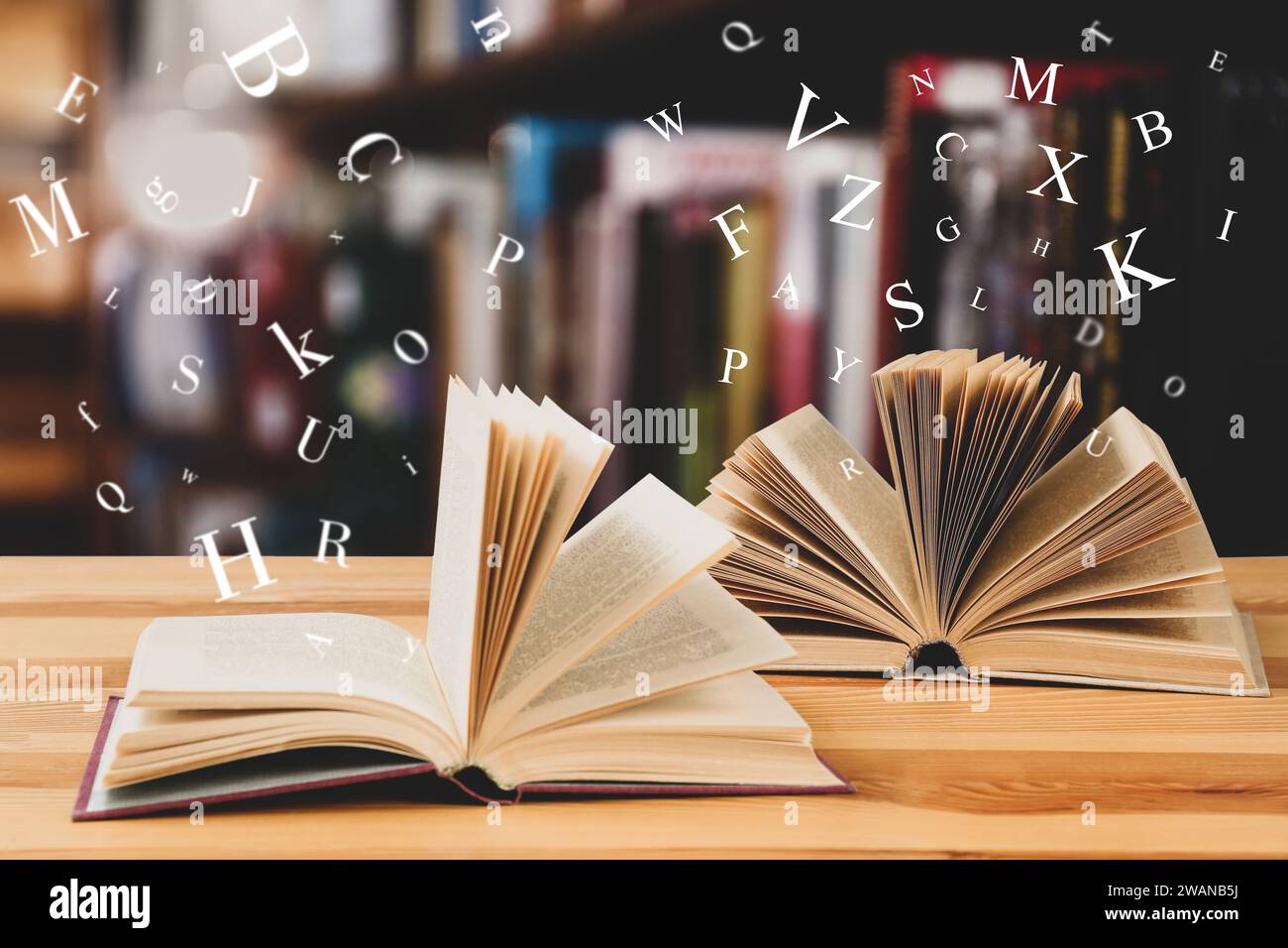 Open books with letters flying out of it in library Stock Photo - Alamy
