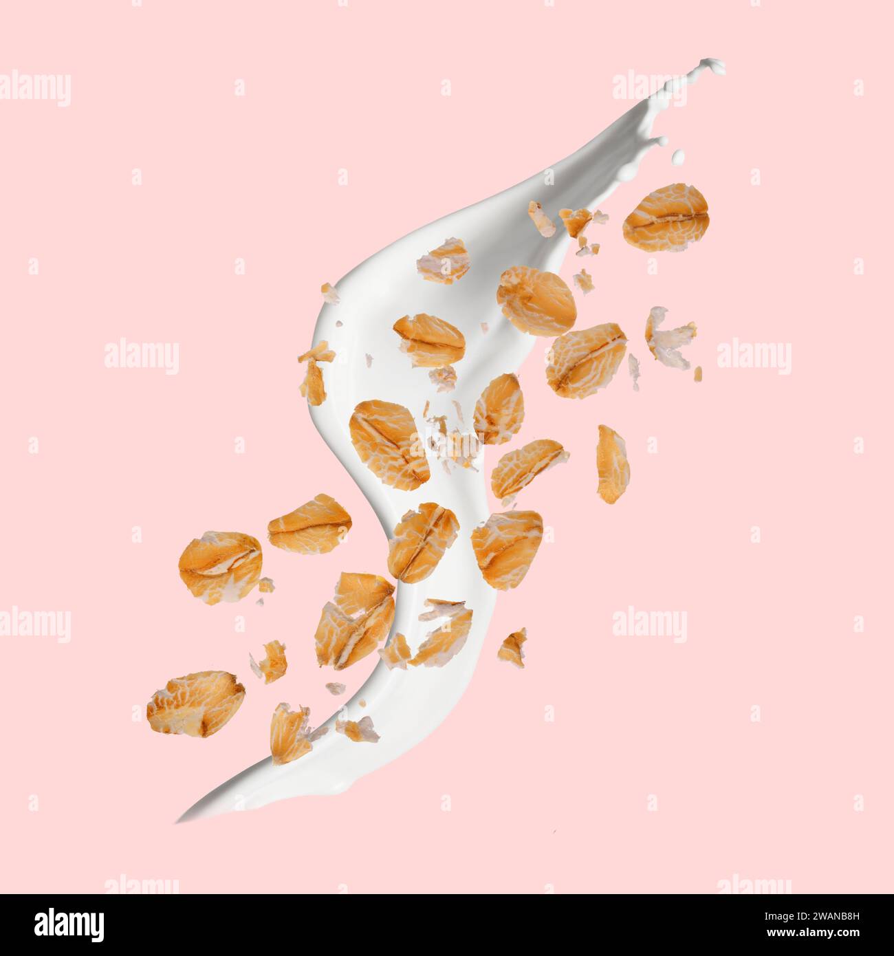 Rolled oats and milk splash on pink background Stock Photo - Alamy