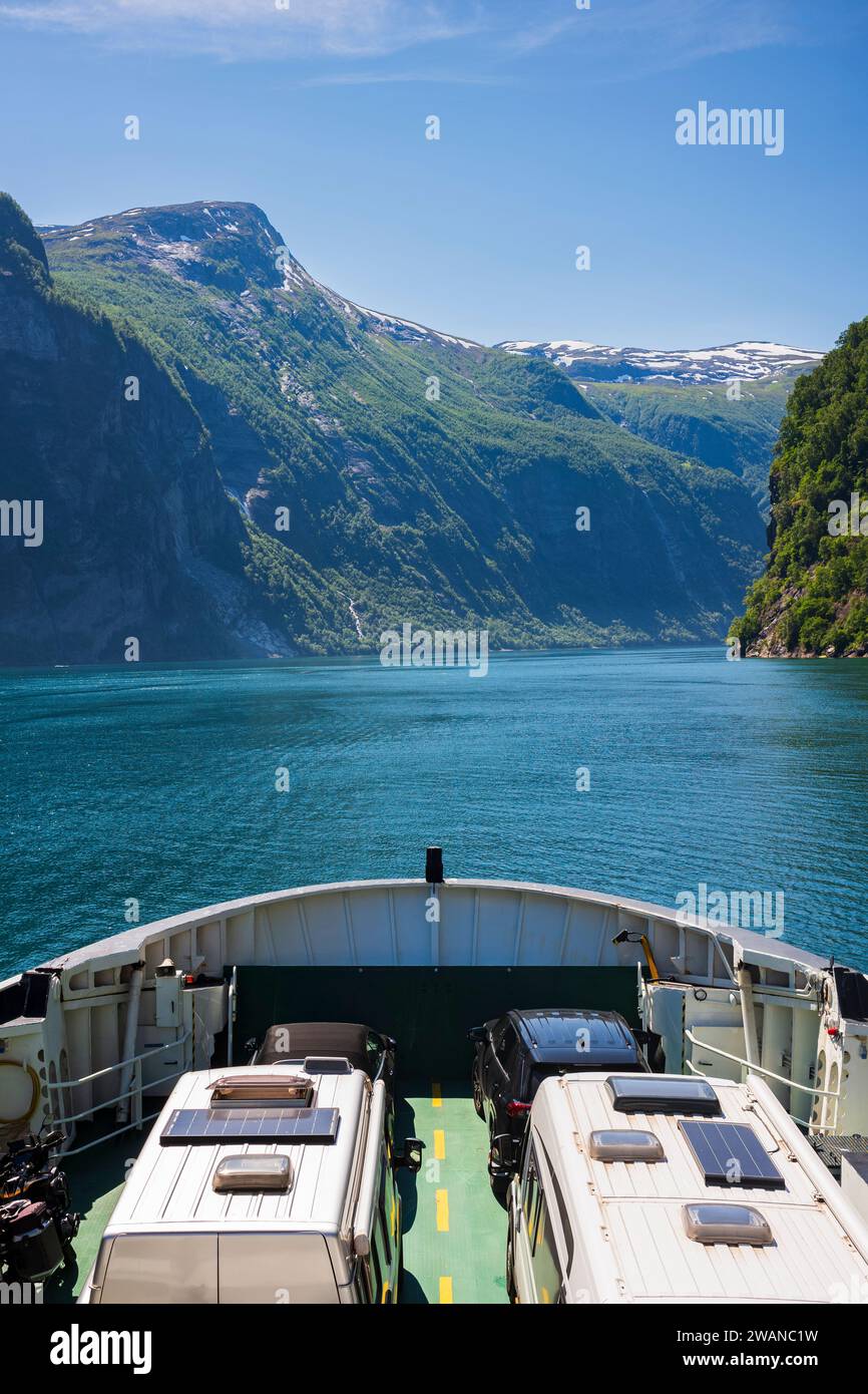 A ferry navigates the waters of Geirangerfjord between the villages of ...
