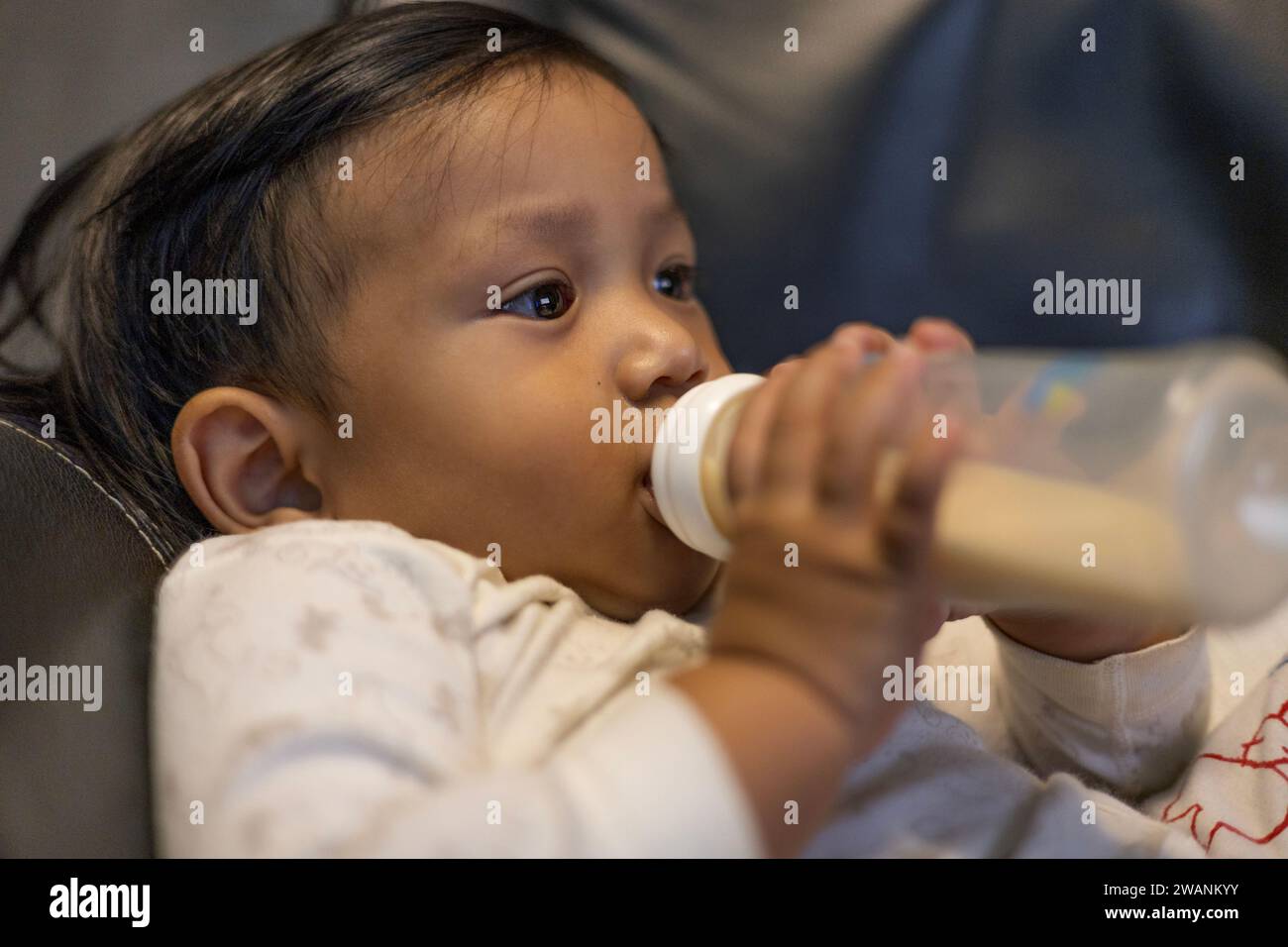 Baby Drinking Milk From The Bottle. Close up of feeding baby with milk ...