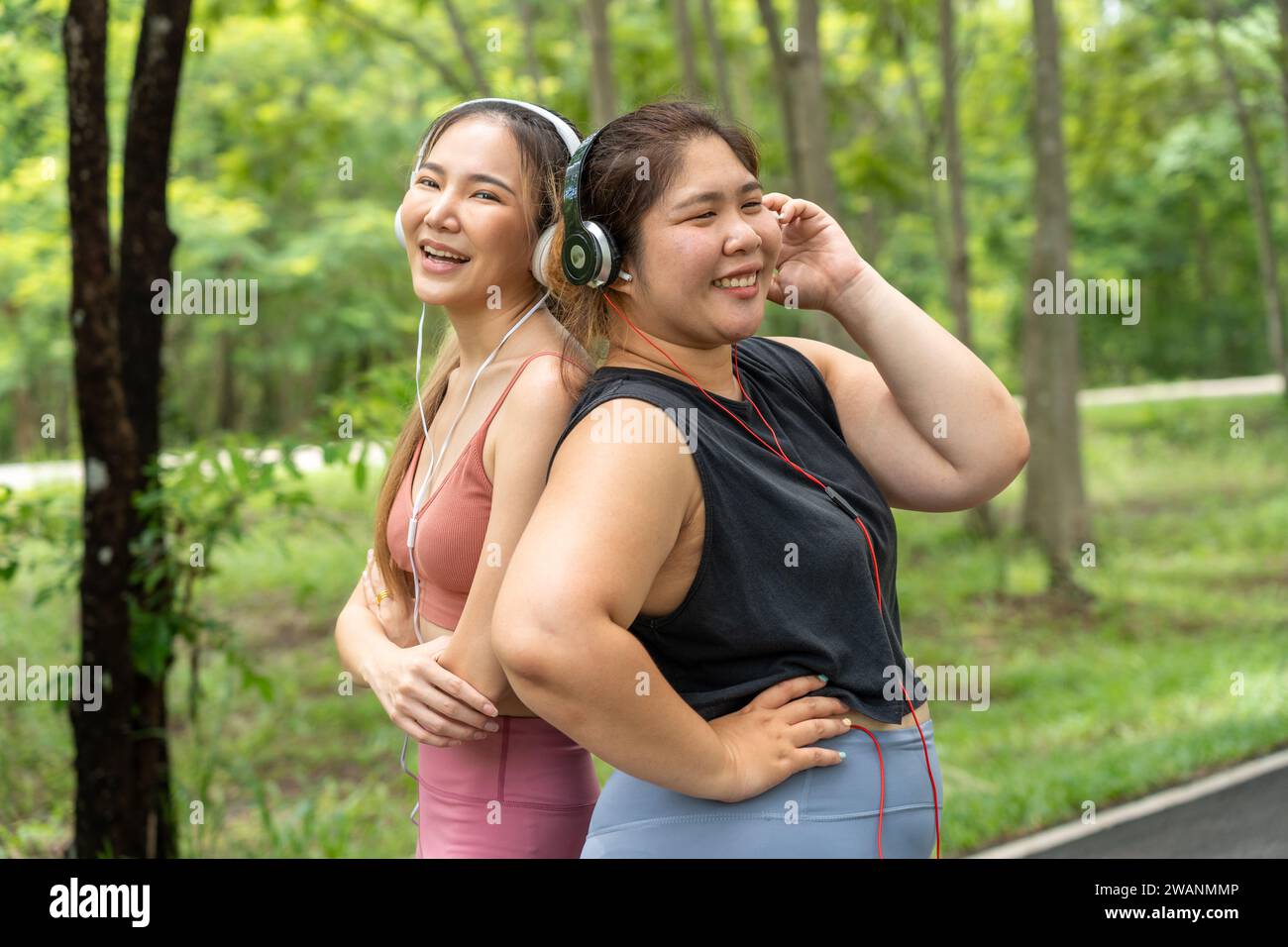 Two happy Asian female friends, one over size and one lean, standing ...