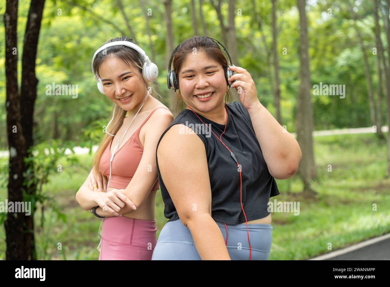 Two happy Asian female friends, one over size and one lean, standing ...