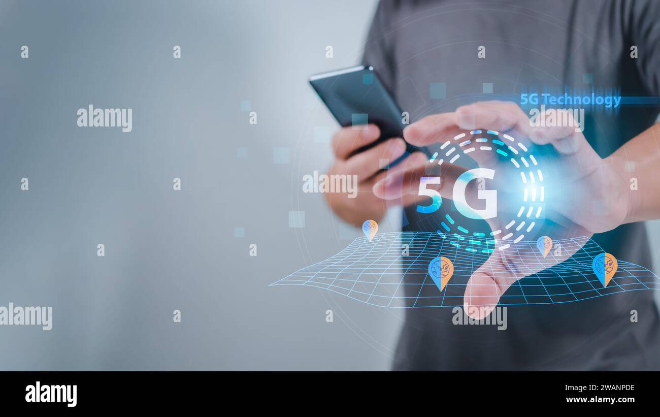 Close-up of human hand holding smartphone and pointing at 5G hologram, 5G wireless network ...
