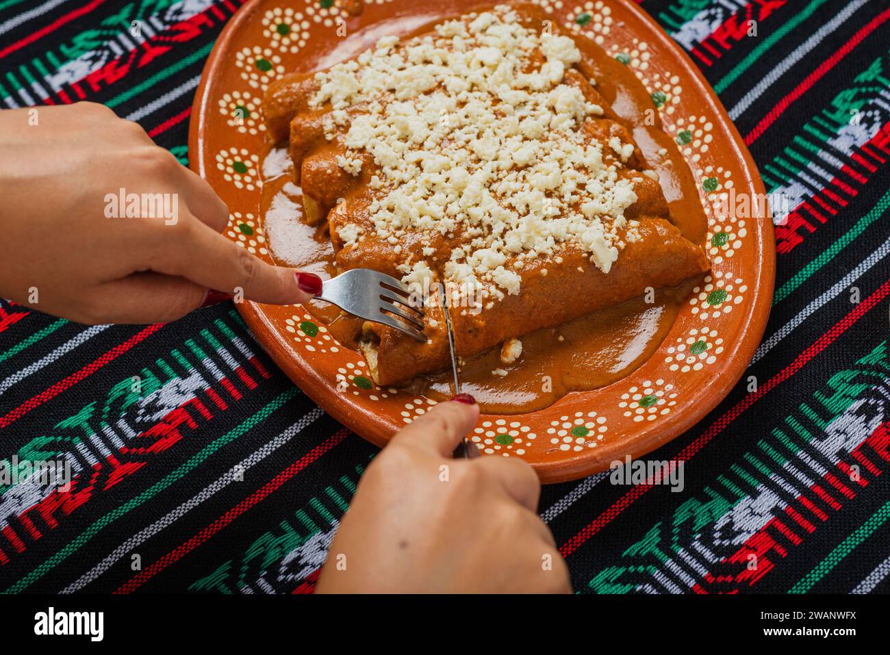 Person eating enchiladas with red pipian. Typical Mexican food Stock ...