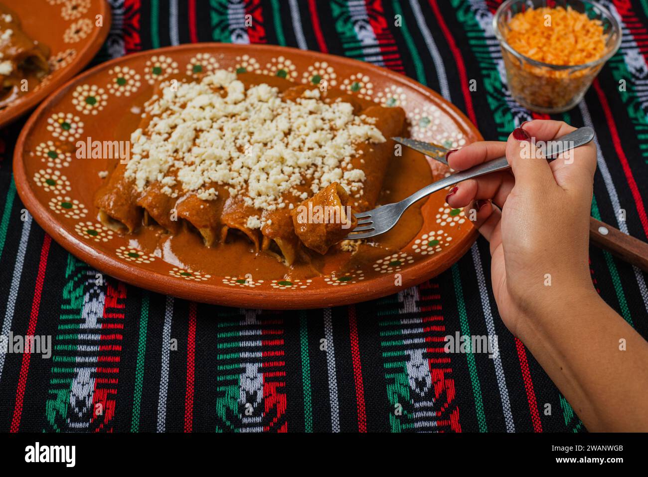 Person eating enchiladas with red pipian. Typical Mexican food Stock ...