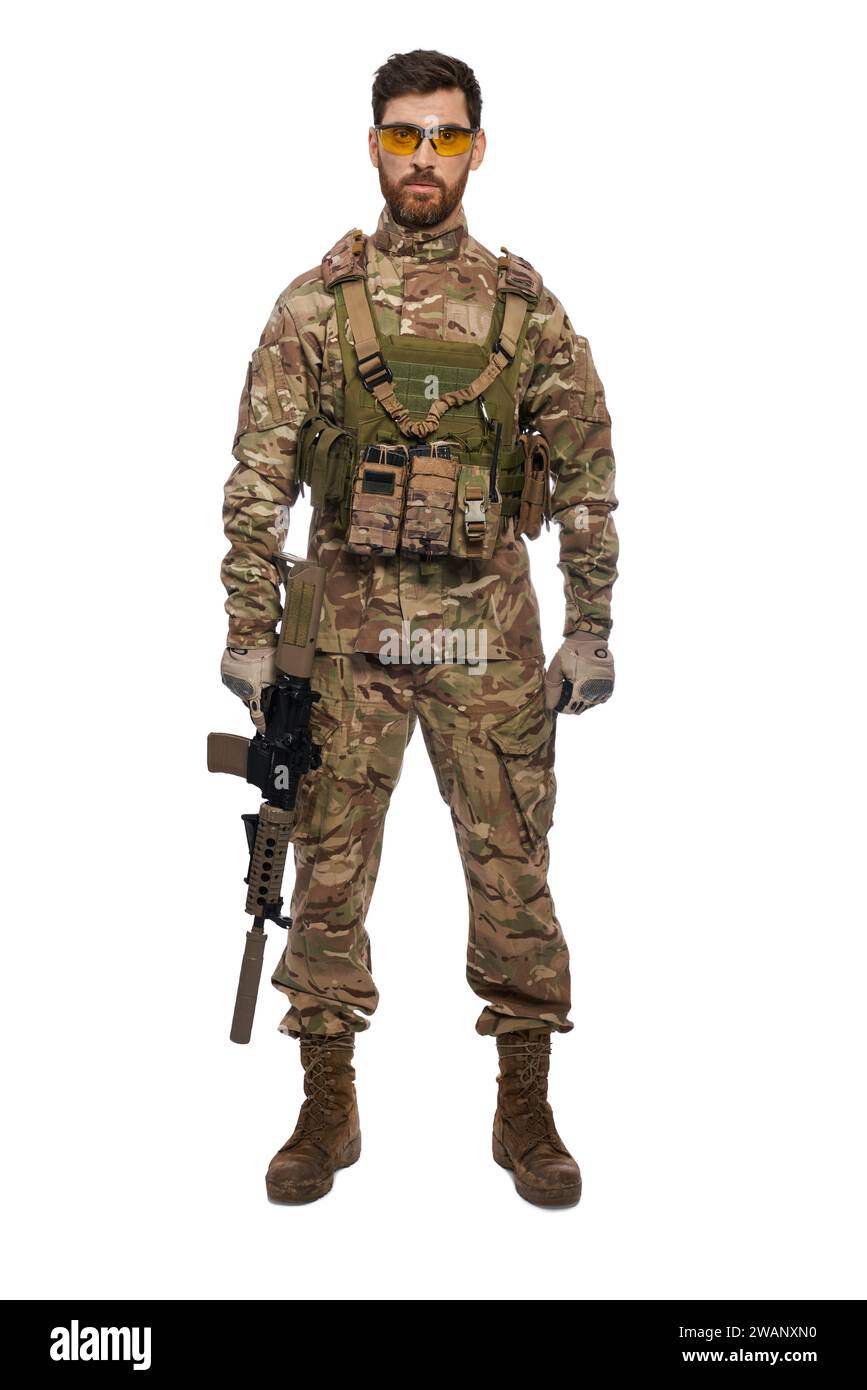 Strong male caucasian military soldier with rifle standing in studio. Front view of handsome ...