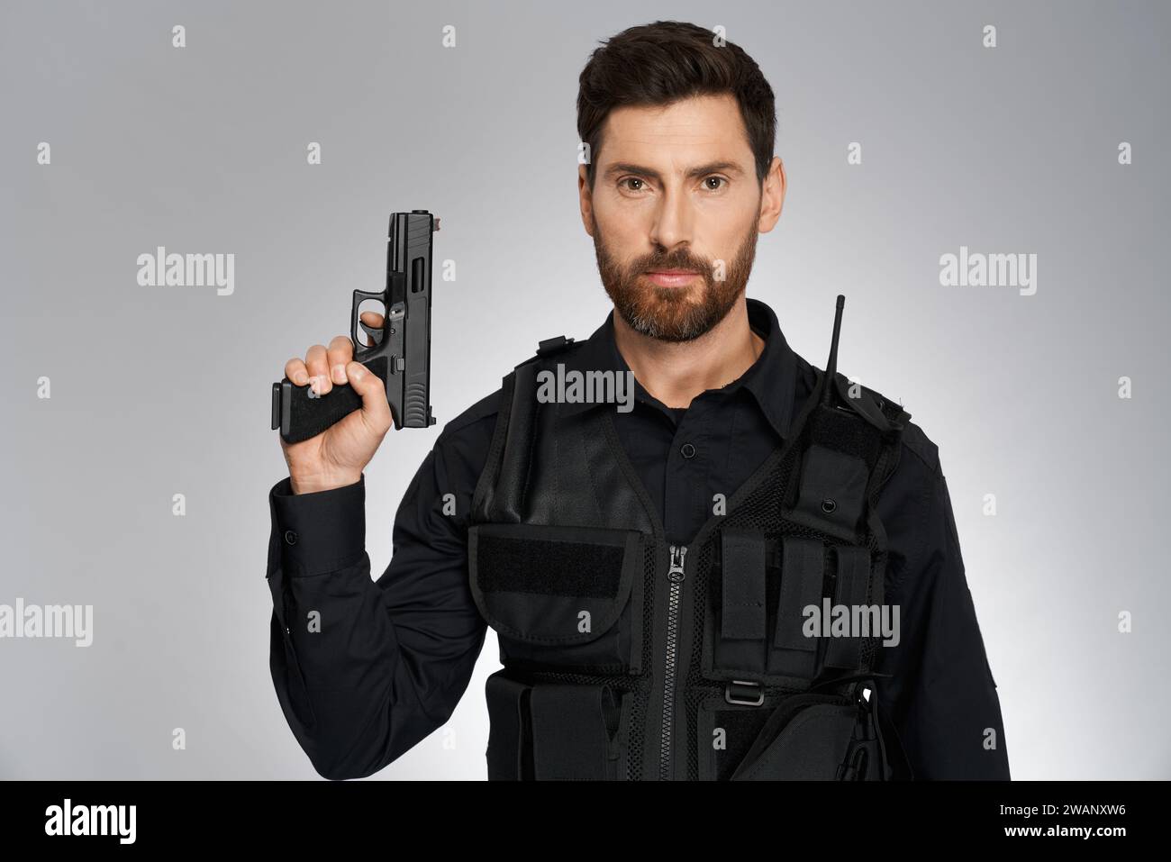 Handsome bearded cop with handgun, posing to camera. Portrait of ...