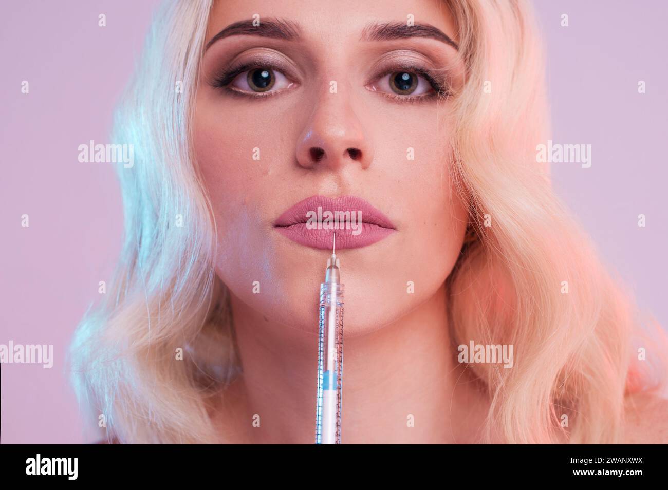 A blonde poses with a syringe. Botox beauty procedure Stock Photo - Alamy