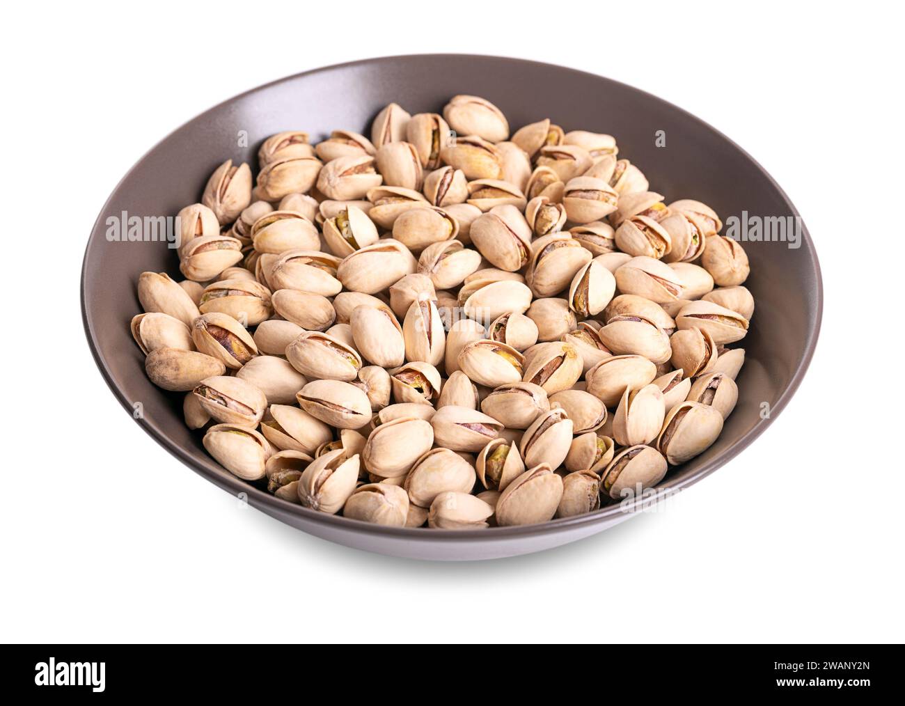 Roasted and salted pistachios in their shells, in a brown bowl. Crunchy roasted fruits of ...