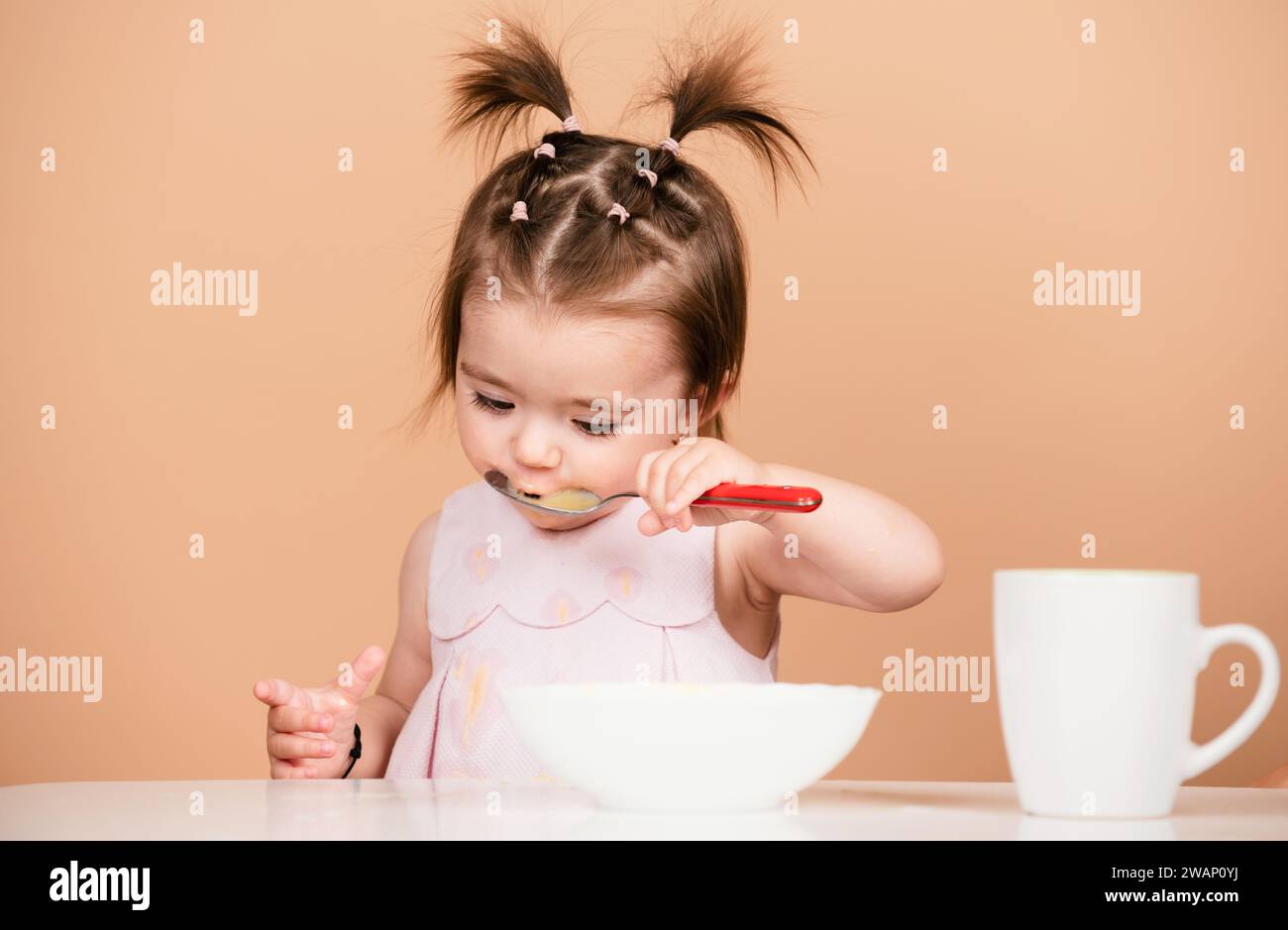 Kid eat healthy nutrition, baby food. Babies eating with spoon. Lick ...