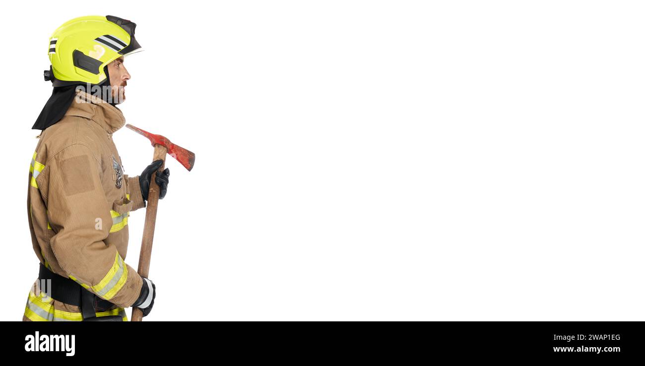 Serious bearded firefighter holding axe tool. Side view of focused male ...