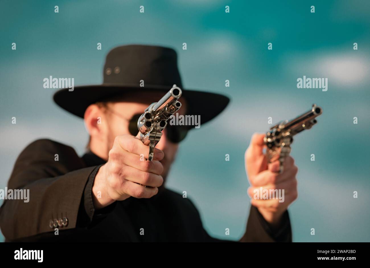 Sheriff in black suit and cowboy hat shooting gun, close up western ...