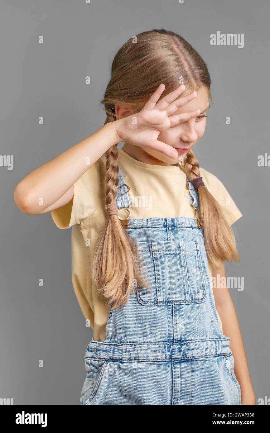 A little girl shows a sign of prohibition or protest with her hand ...
