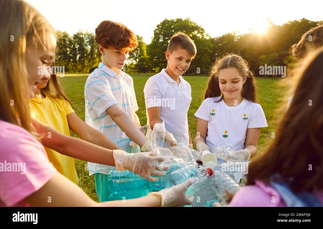 Group of kids standing with garbage bags collecting plastic trash in ...