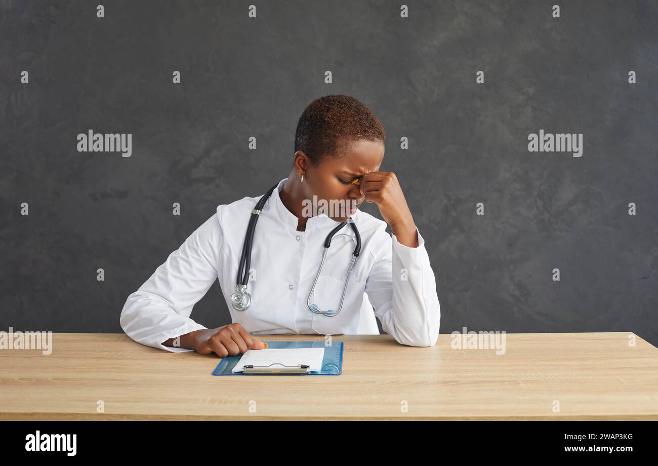Tired and upset woman doctor thinks about the result of examination of ...