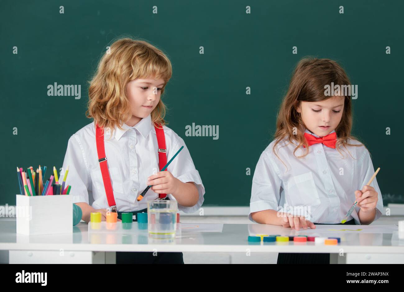 Cute school friends kids drawing and painting at school. Friendly boy ...