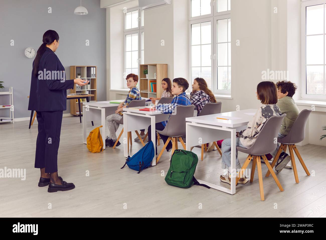 Woman teacher standing back in the classroom in junior high school with ...