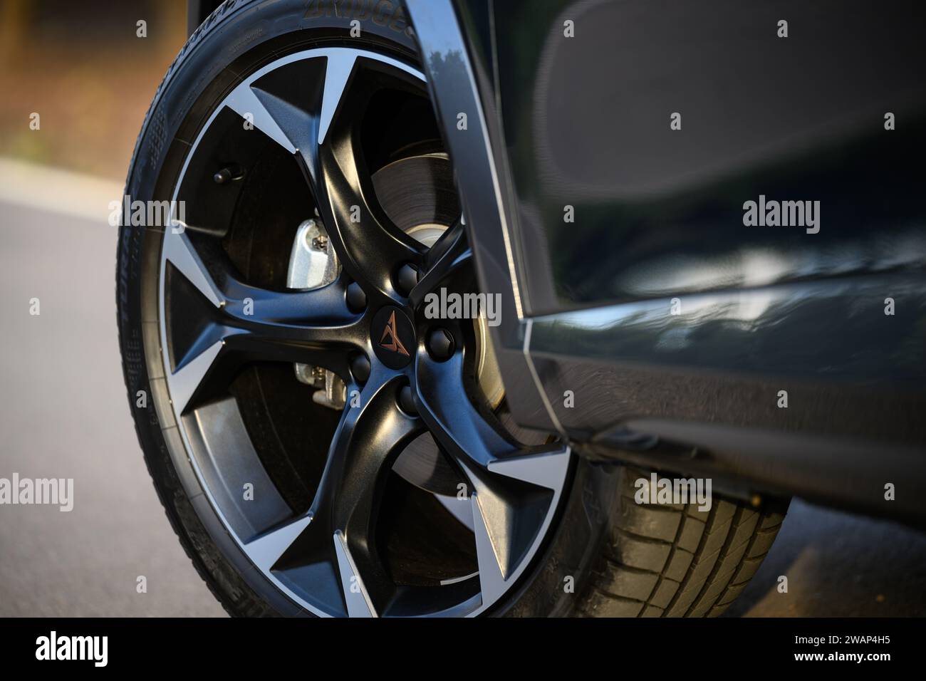Detail of an aluminium and black rim with a Cupra car tyre with the ...