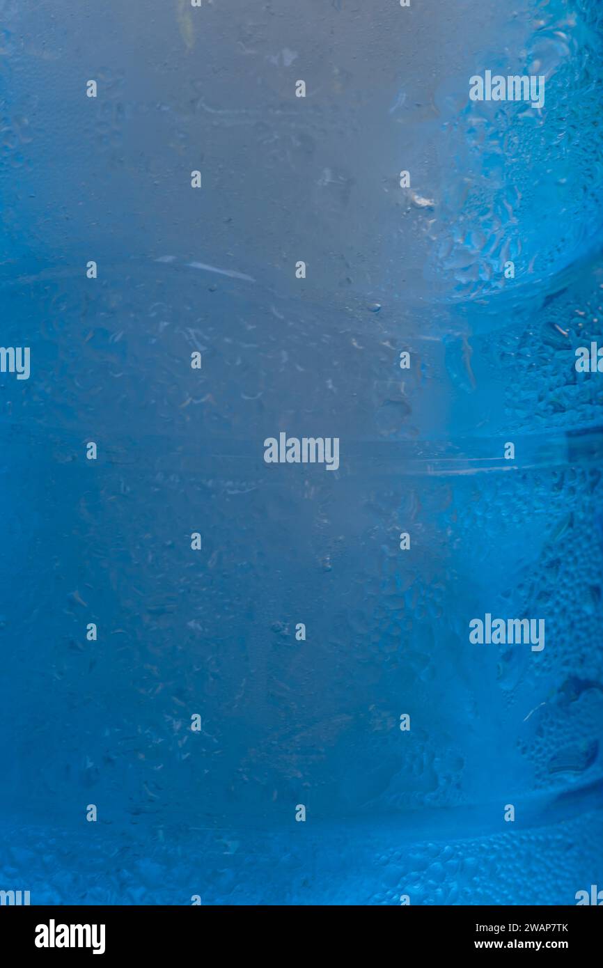 Closeup of bottle of water and ice back lit with LED lights and blue ...