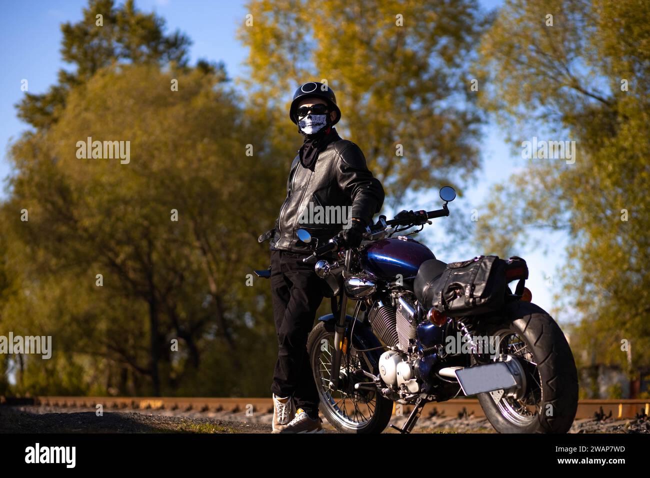 Male motorcyclist in a leather jacket and helmet on a vintage custom ...