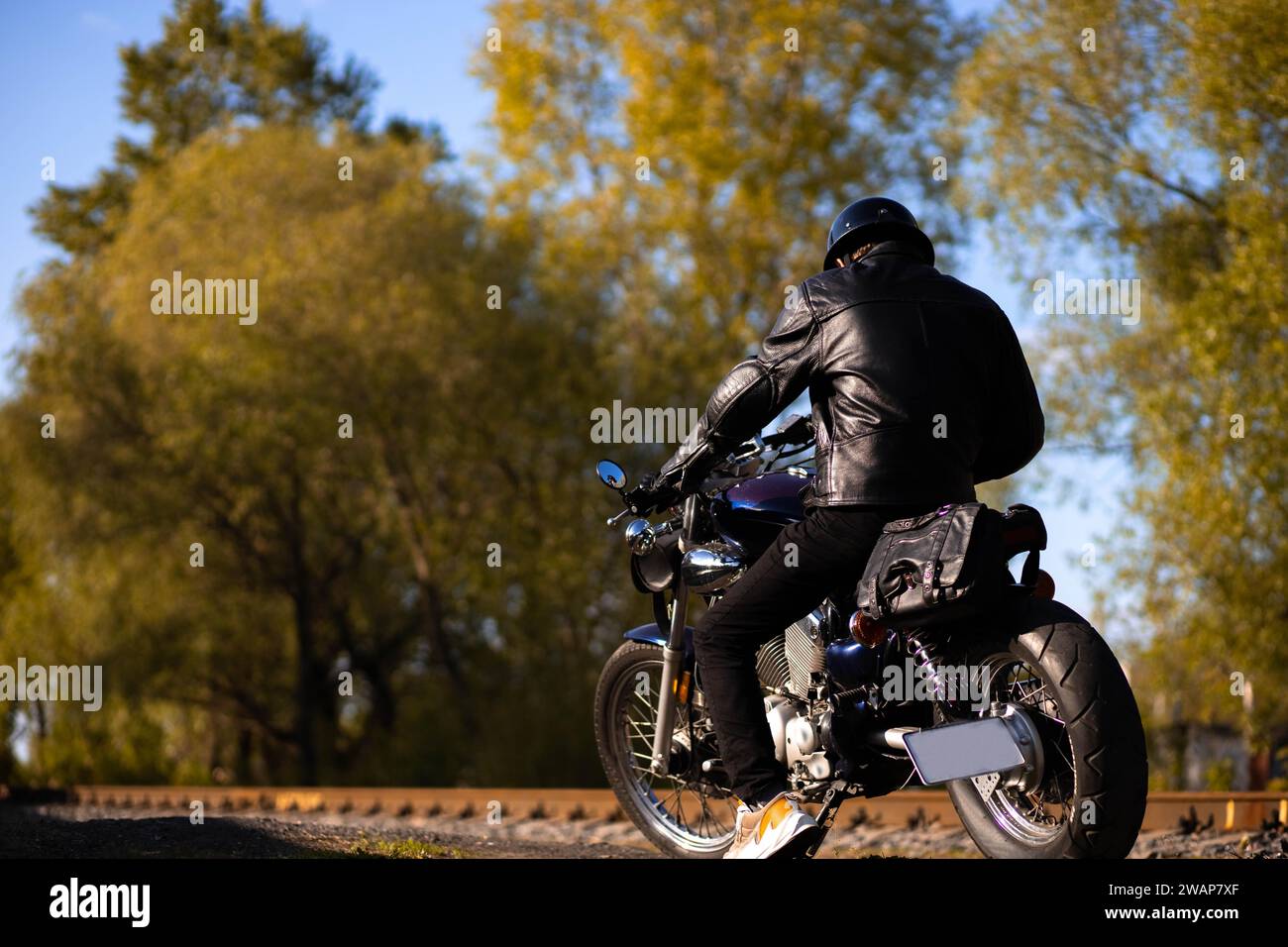 Male motorcyclist in a leather jacket and helmet on a vintage custom ...