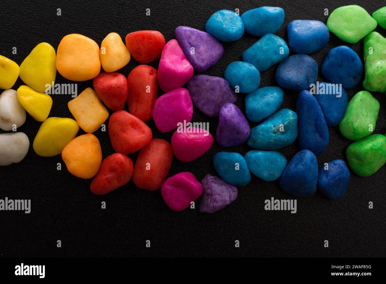 Pile of little colorful pebbles on black background Stock Photo - Alamy