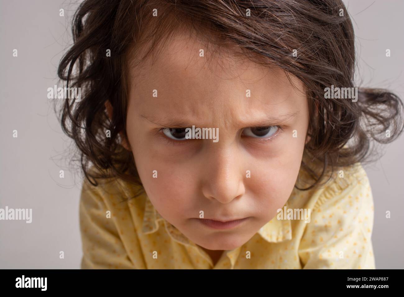 Little cute boy trying to make a serious face Stock Photo - Alamy