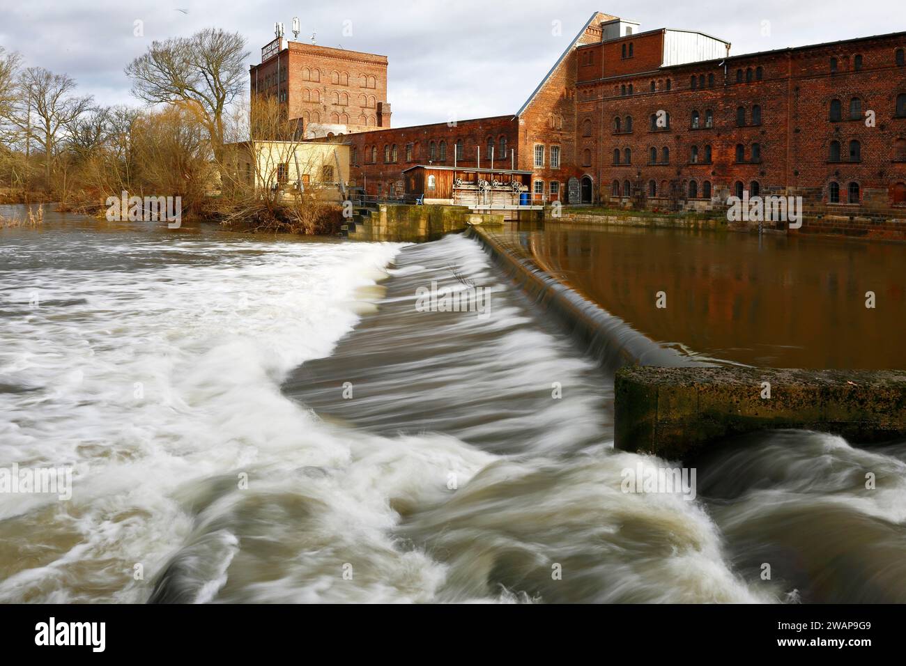 Overflowed weir of the Jonitzer Mulde near Dessau, historic watermill ...
