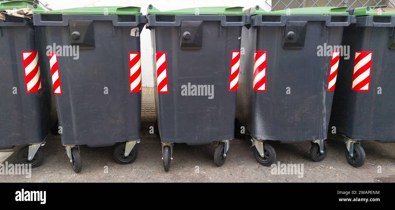 Line of grey dumpsters on sideway. Long format view Stock Photo - Alamy