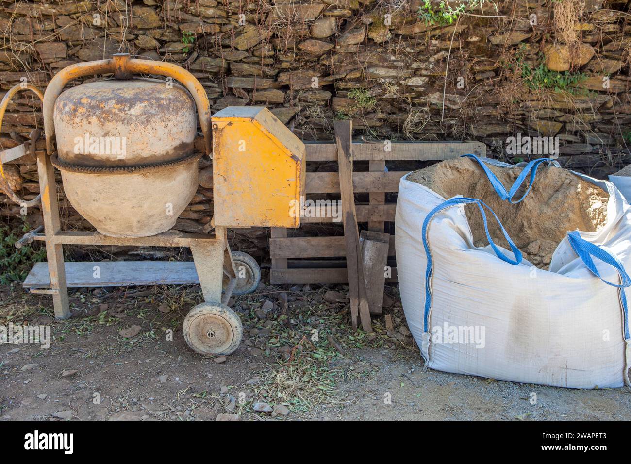 Raffia large sand sack stacked close to cement mixer. Rural residences ...