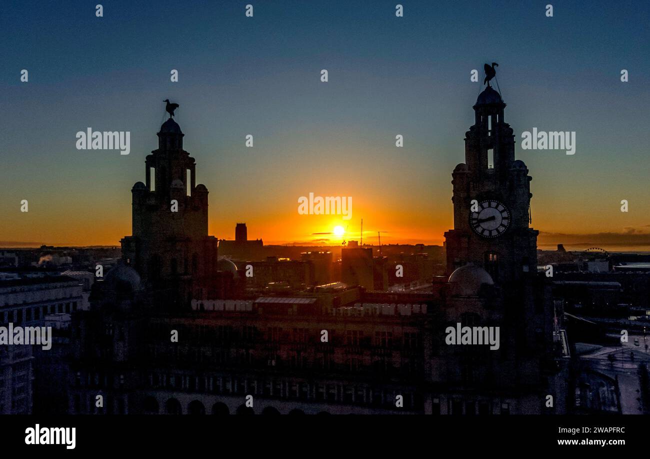 The sun rises behind the Liver Birds, sat atop of the Royal Liver ...