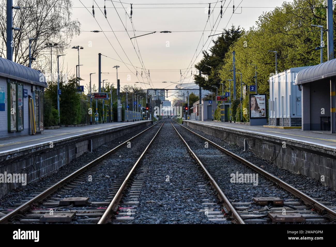 An empty train station, featuring an expanse of tracks that stretch out ...