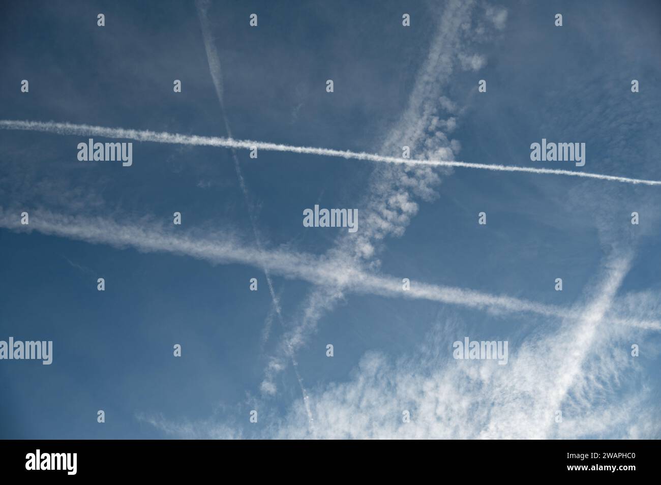Contrails in clear winter sky Stock Photo - Alamy