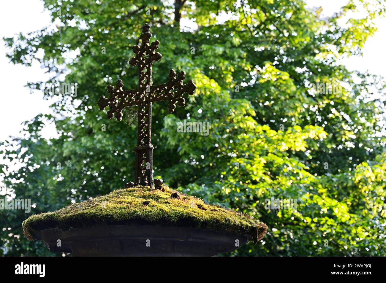 Old metal cross on mossy pillar with light shining from the side Stock ...