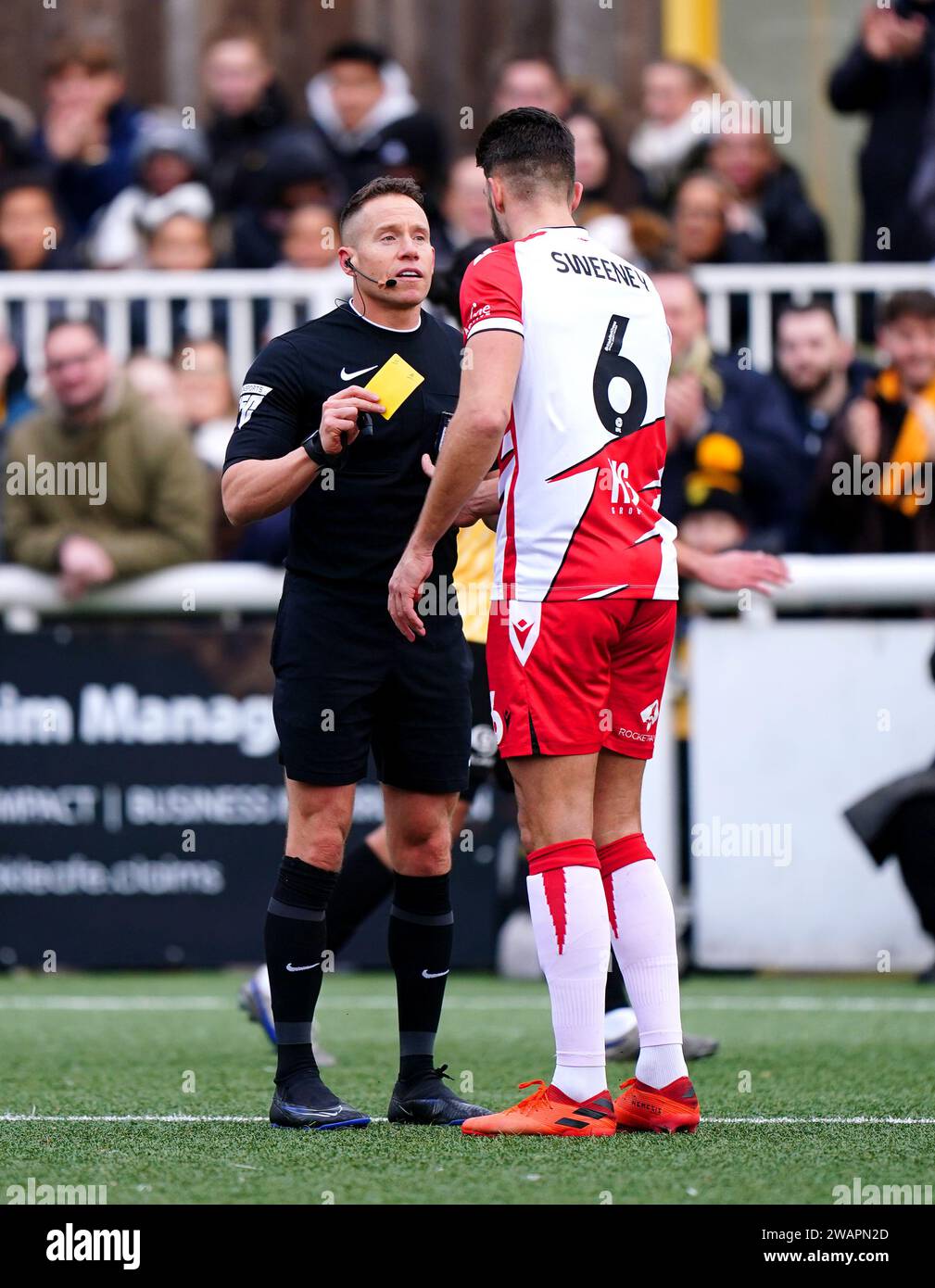 Stevenage's Dan Sweeney is shown a yellow card by referee Steve Martin ...