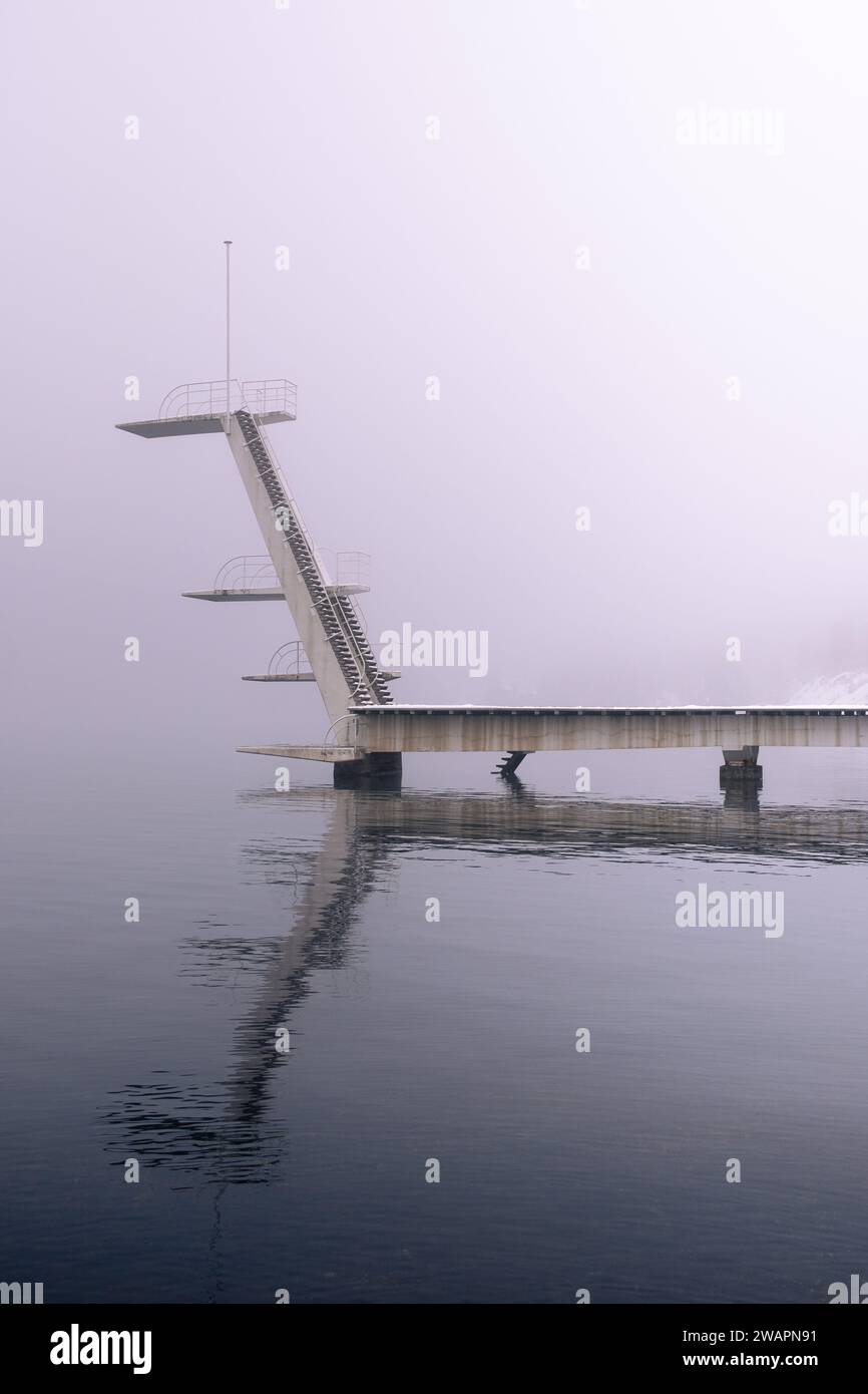 A vertical of a concrete pier over the sea on a foggy day in ...