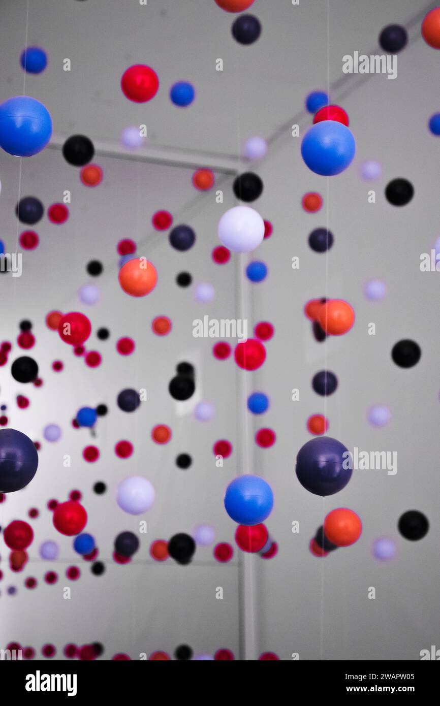 artistic display of colored spheres hanging from the ceiling with a ...