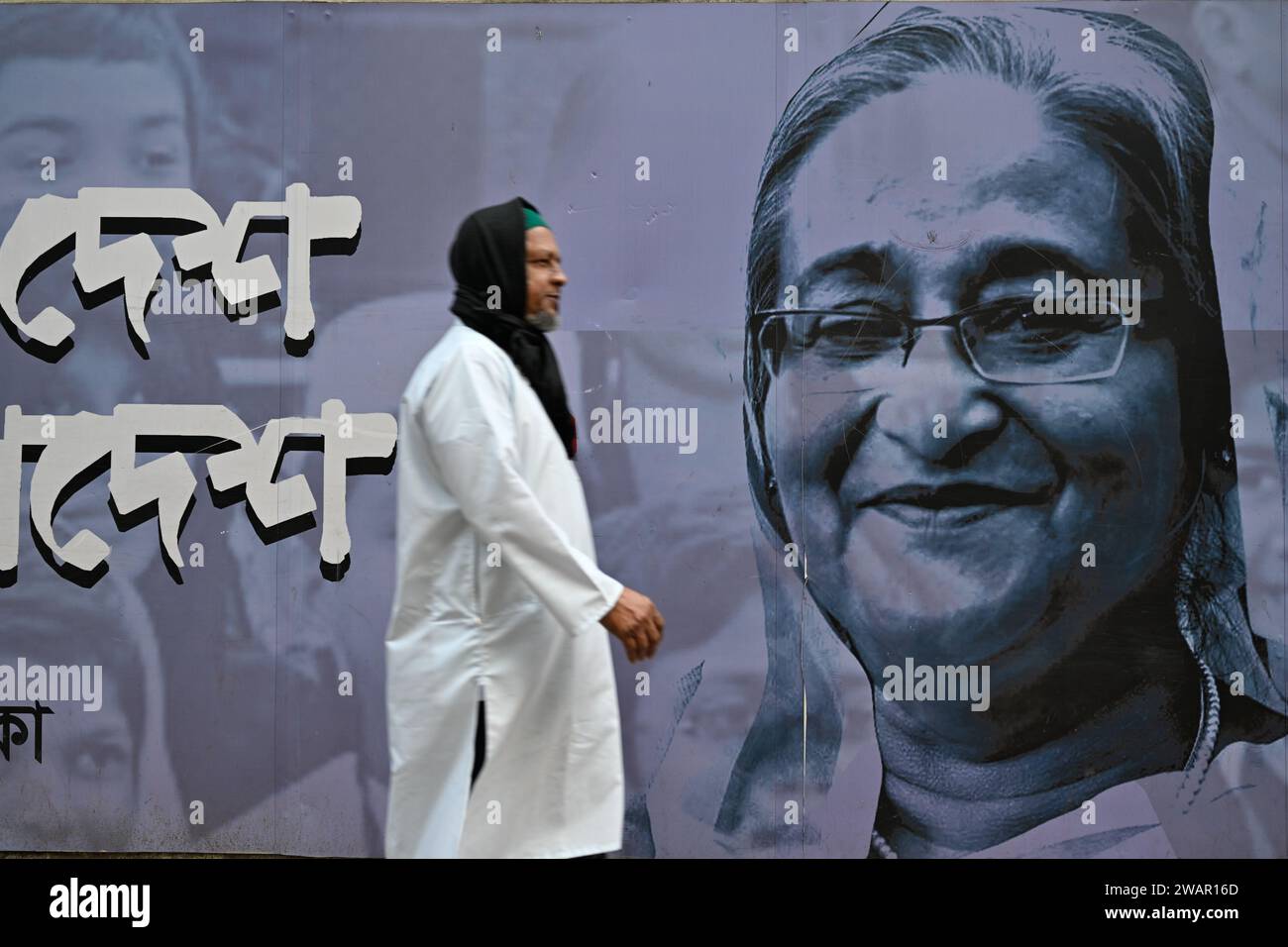 Dhaka, Dhaka, BANGLADESH. 6th Jan, 2024. A man walks past a poster of ...