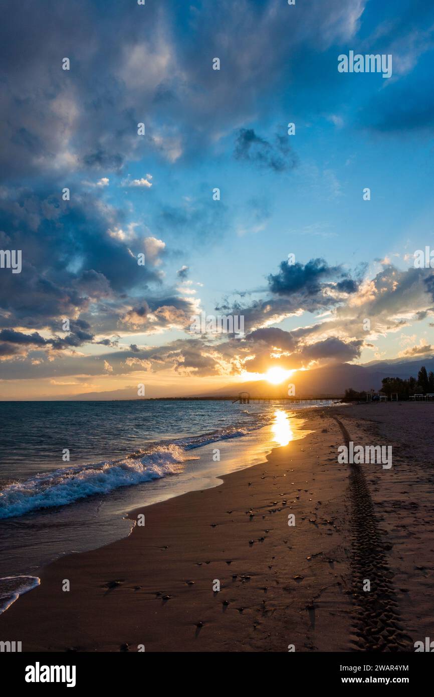 Colorful sunset on the sea. Mountain lake in the rays of the orange sun ...