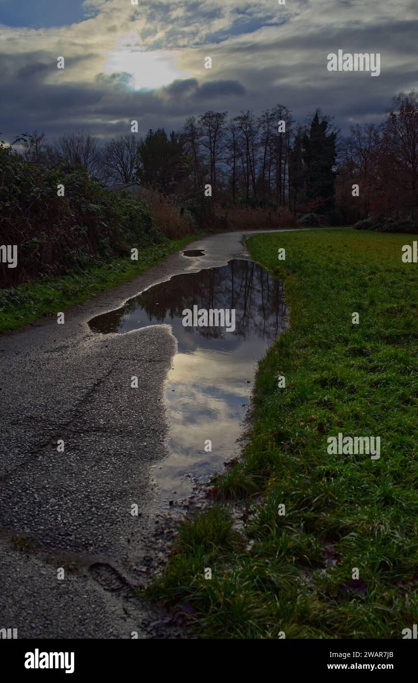 Scenery of puddles on the road with water reflections of rural ...