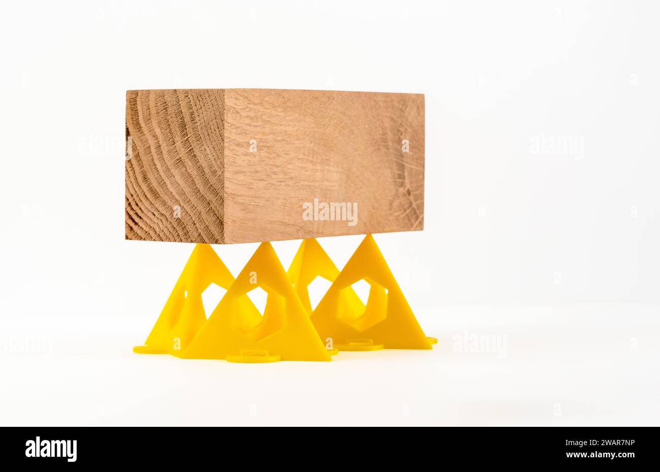 Wooden block supported on yellow stackable painters display pyramid ...