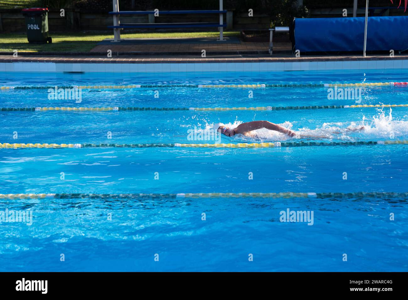 Two people enjoying a leisurely swim in a sparkling blue pool Stock ...