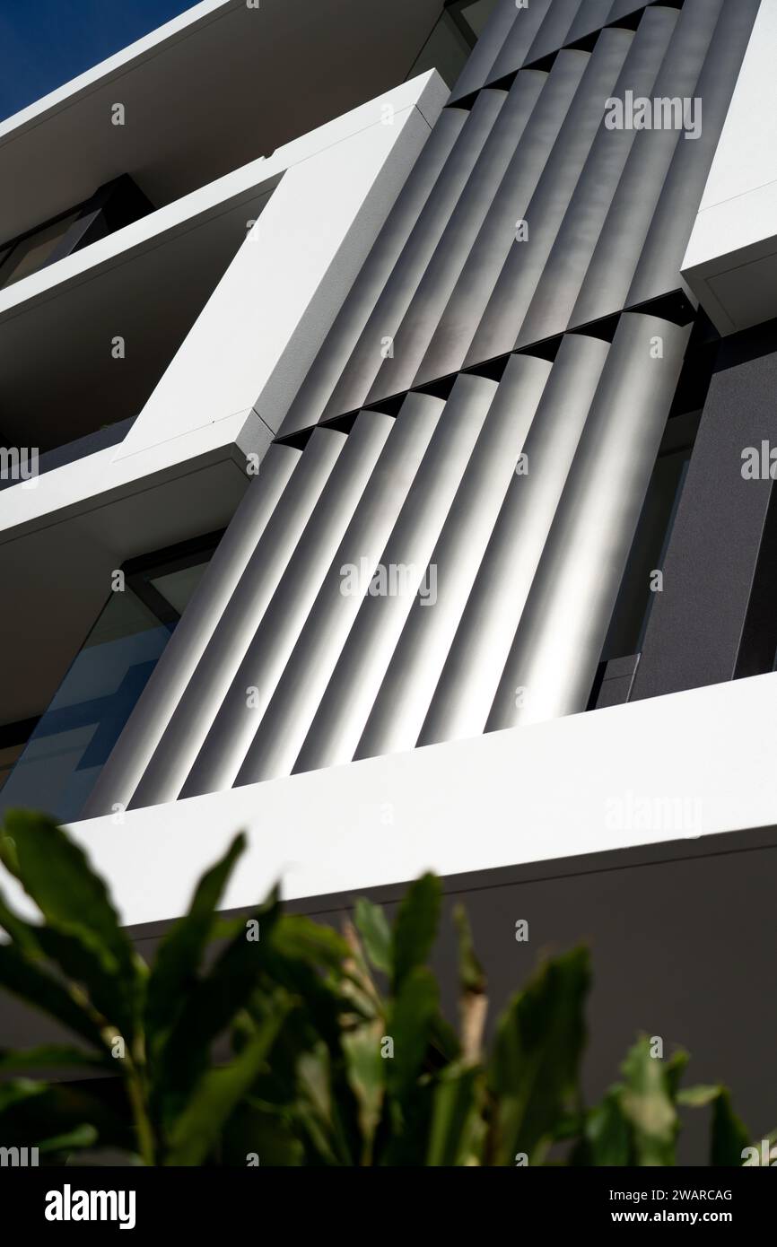 This modern building features expansive windows and lush greenery in ...